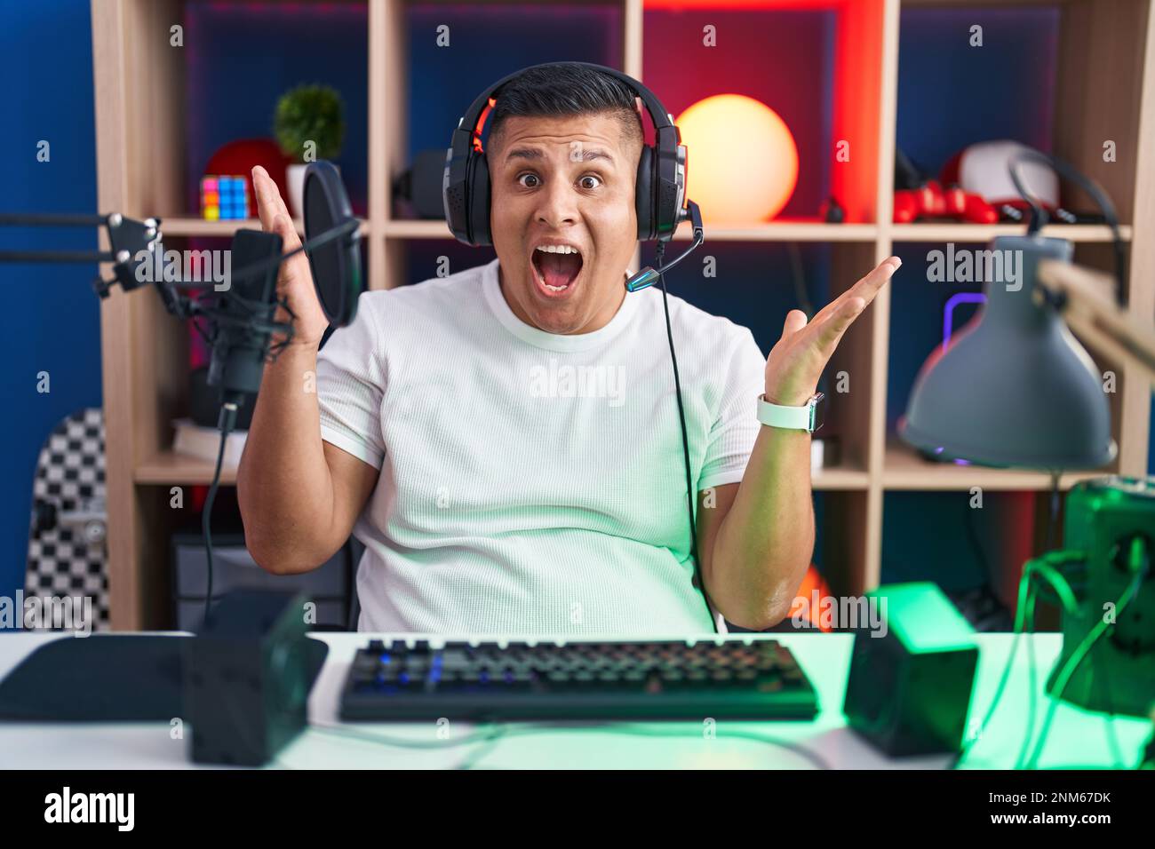 Young hispanic man playing video games celebrating crazy and amazed for ...