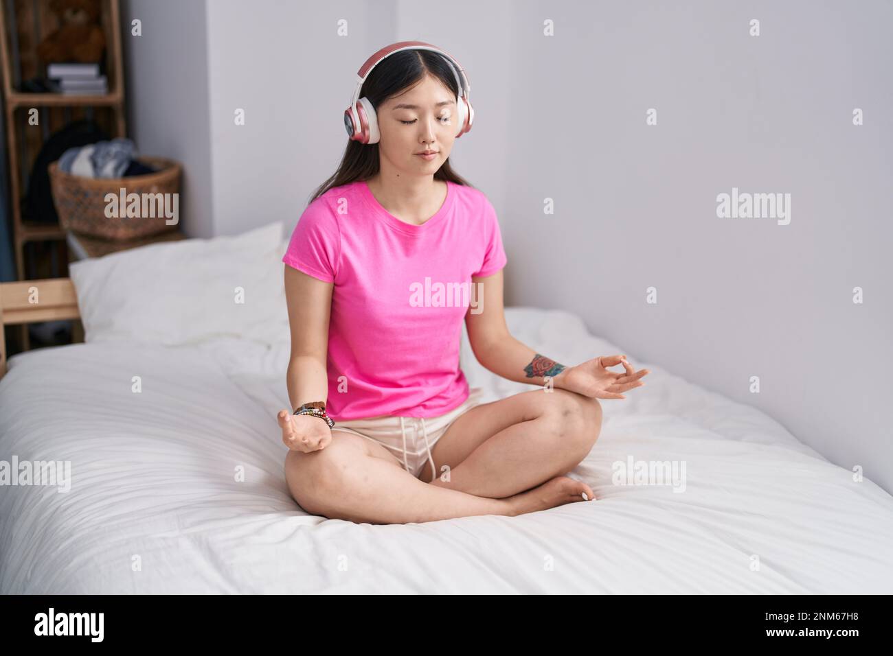 Chinese woman doing yoga exercise sitting on bed at bedroom Stock Photo ...
