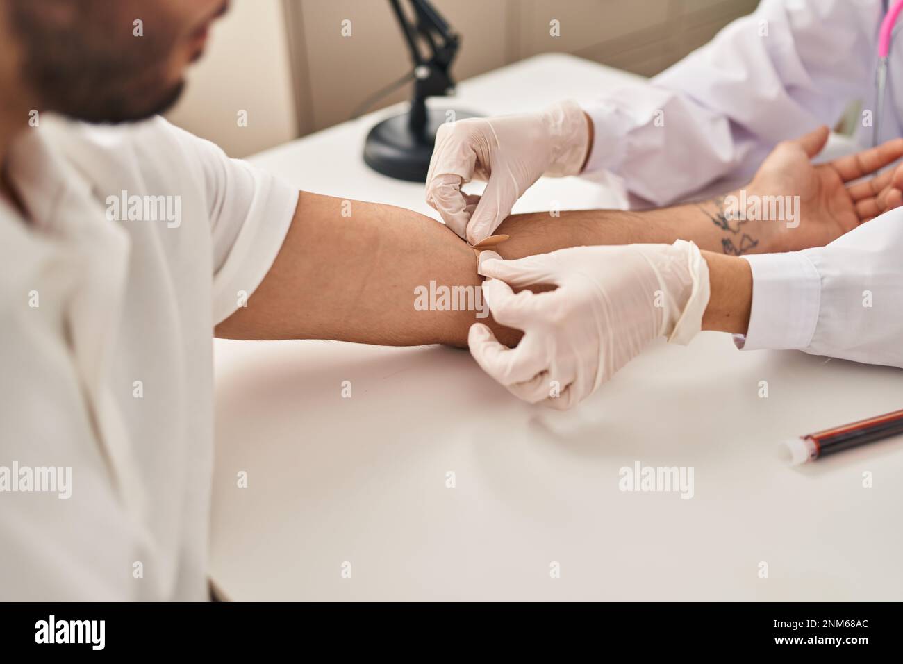 Man and woman wearing doctor uniform having blood analysis at clinic ...