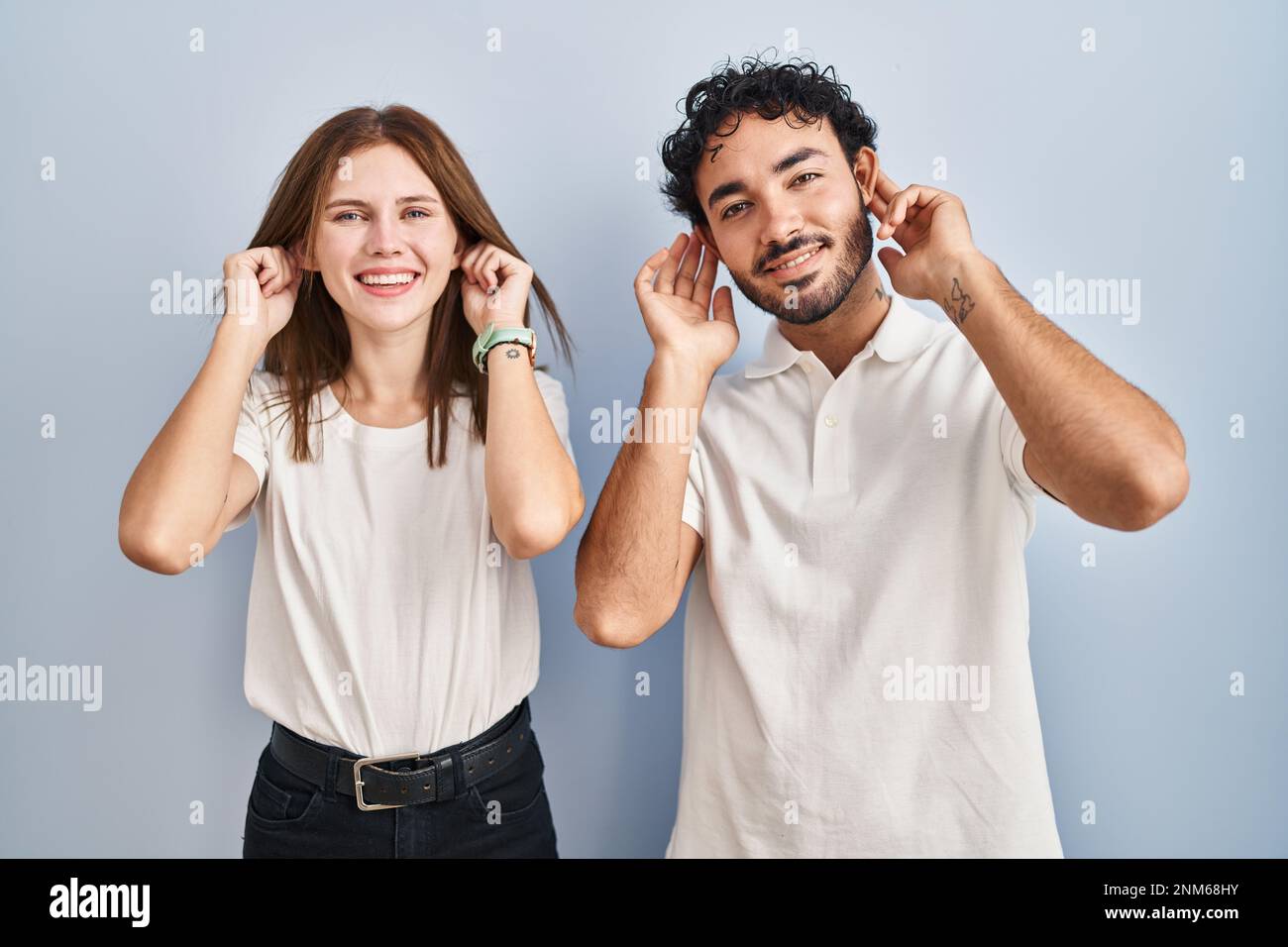 Young couple wearing casual clothes standing together smiling pulling ...