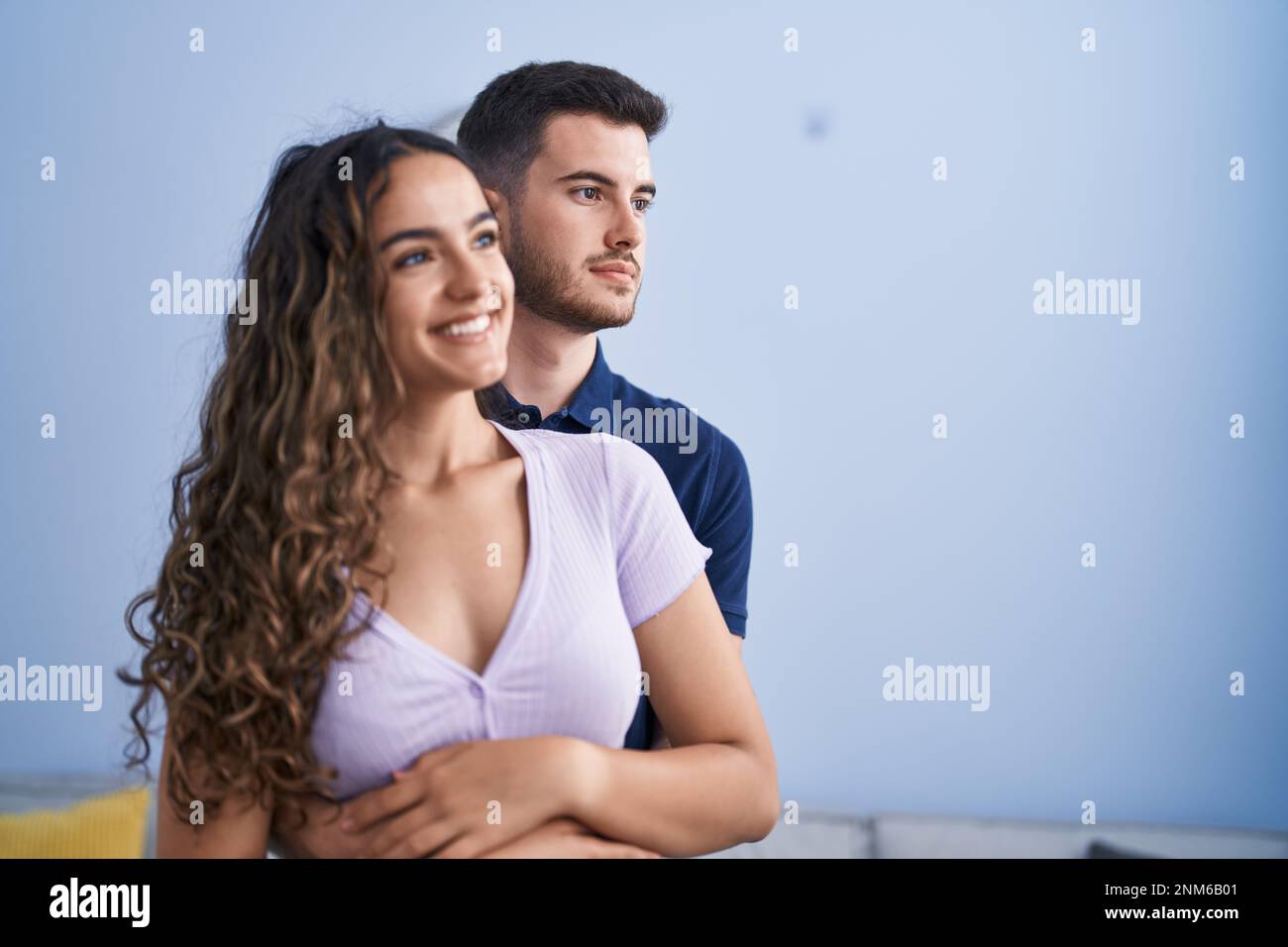 Young hispanic couple hugging each other standing at home Stock Photo ...