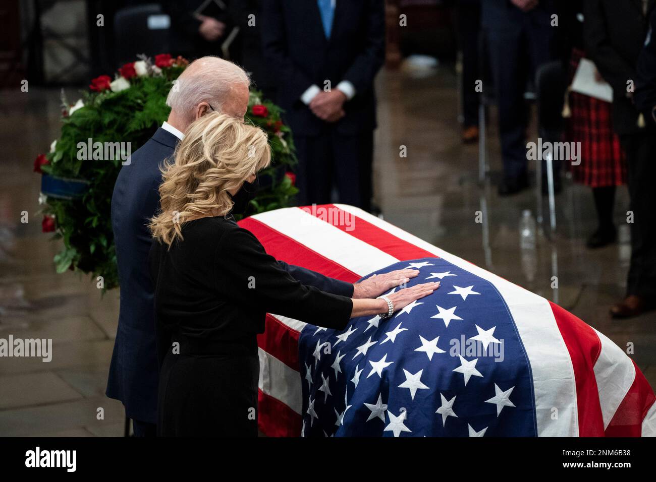 President Joe Biden and first lady Jill Biden touch the flag-draped ...