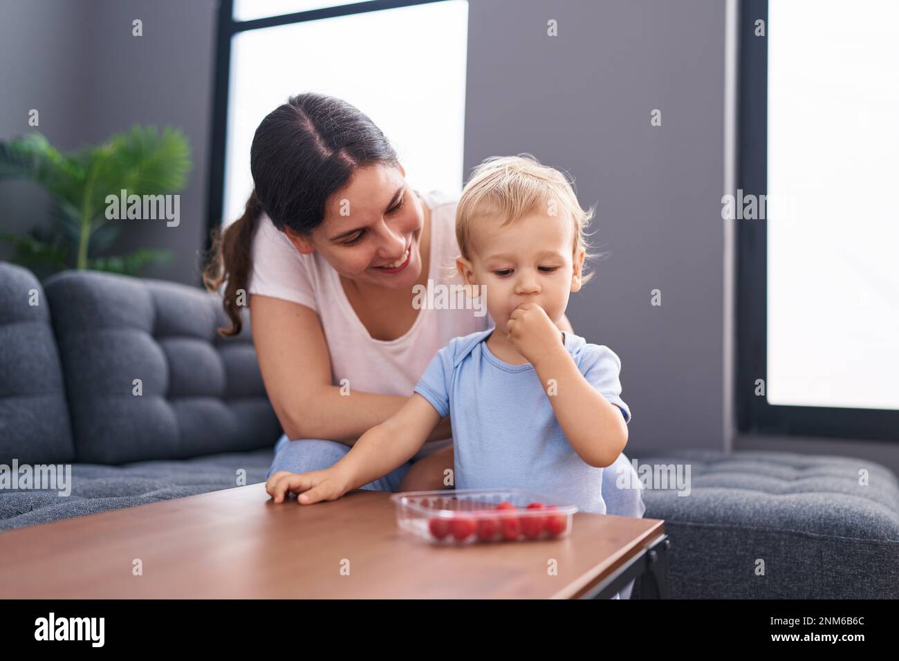 Mother and son smiling confident eating raspberries at home Stock Photo ...