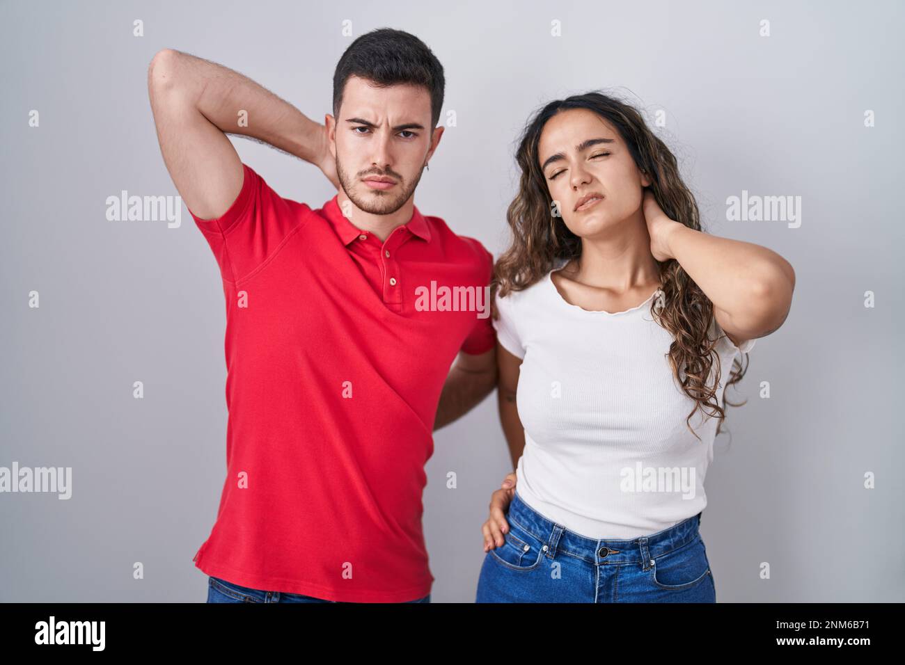 Young hispanic couple standing over isolated background suffering of ...