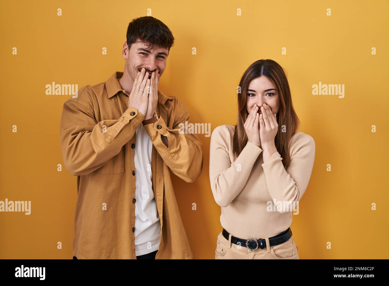 Young hispanic couple standing over yellow background laughing and ... Young hispanic couple standing over yellow background laughing and ...