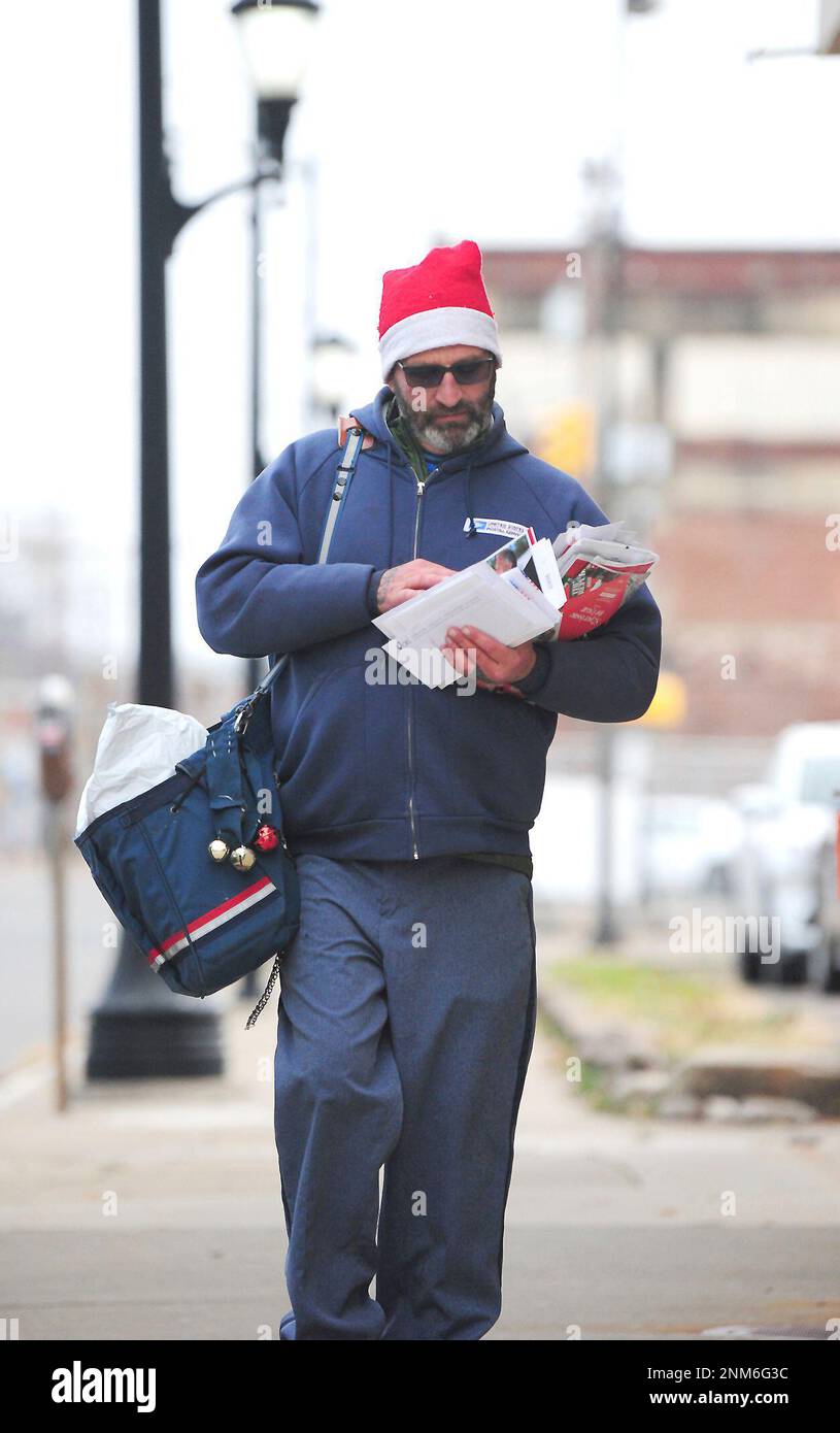 Unites States Postal Service letter carrier David Fey wears a Santa hat ...