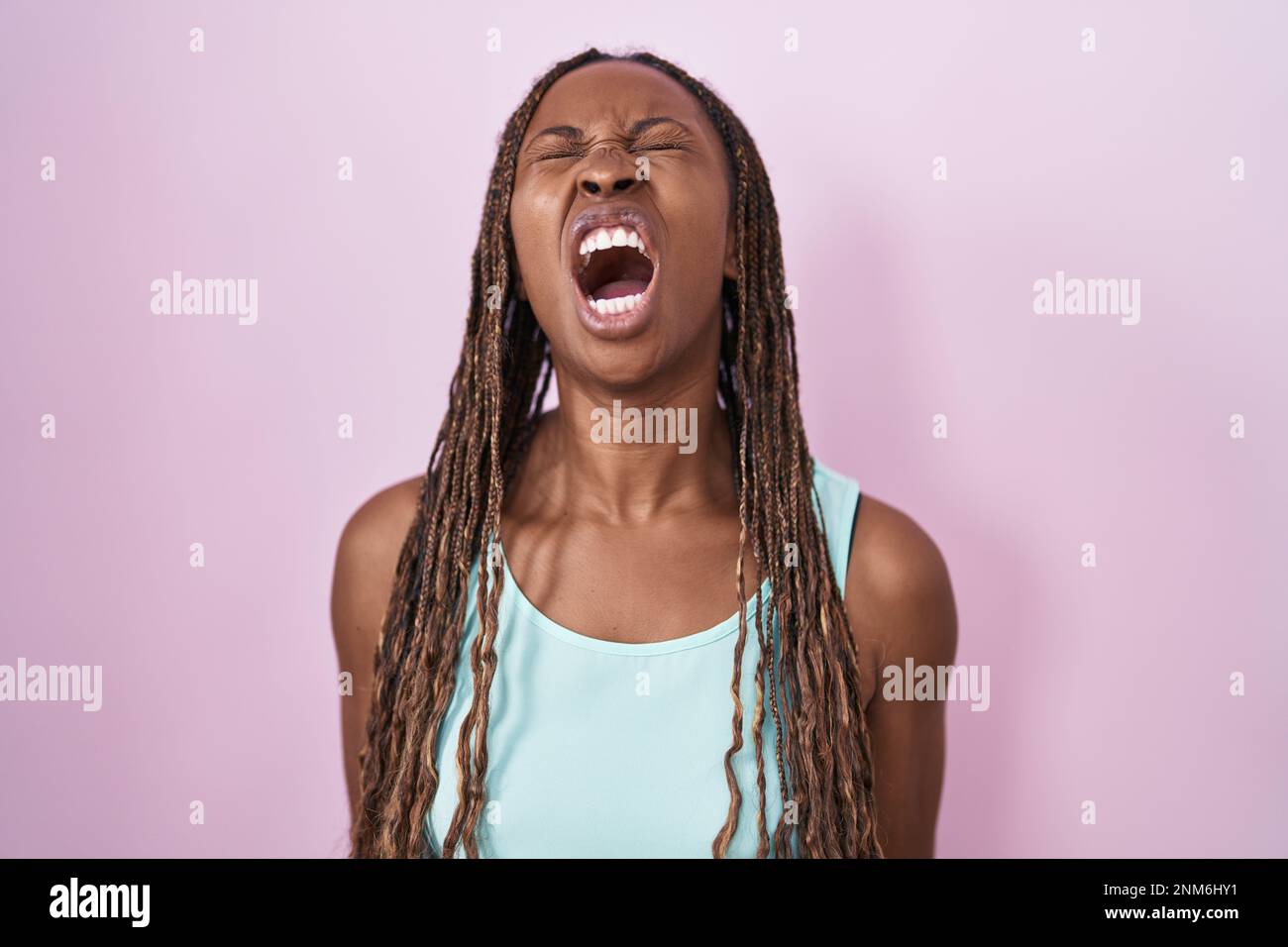 African american woman standing over pink background angry and mad ...