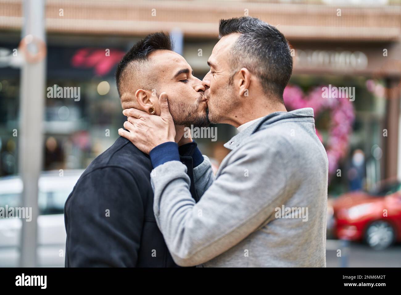Two men couple hugging each other kissing at street Stock Photo - Alamy