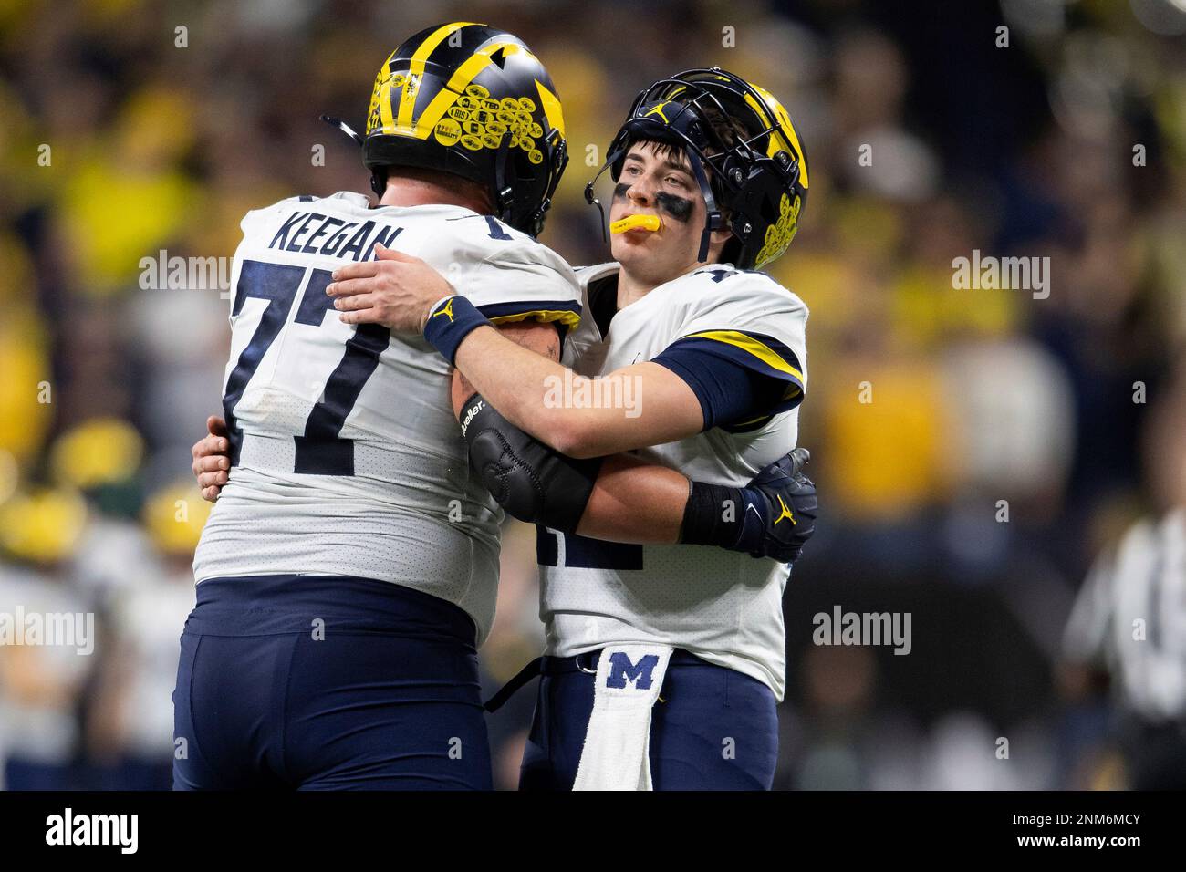 INDIANAPOLIS, IN - DECEMBER 04: Michigan Wolverines quarterback Cade McNamara (12) hugs Michigan ...