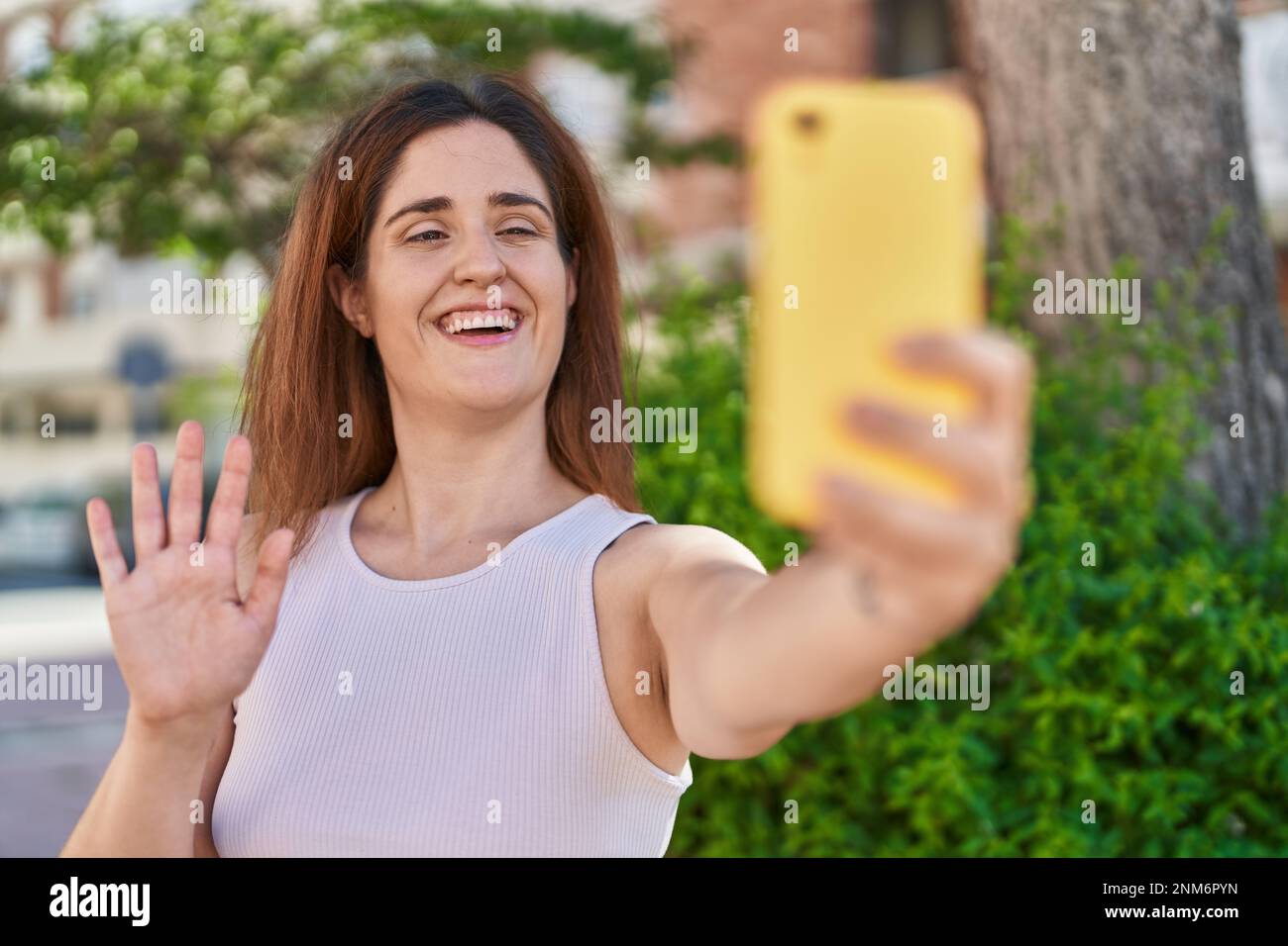Brunette woman taking a selfie photo with smartphone looking positive ...