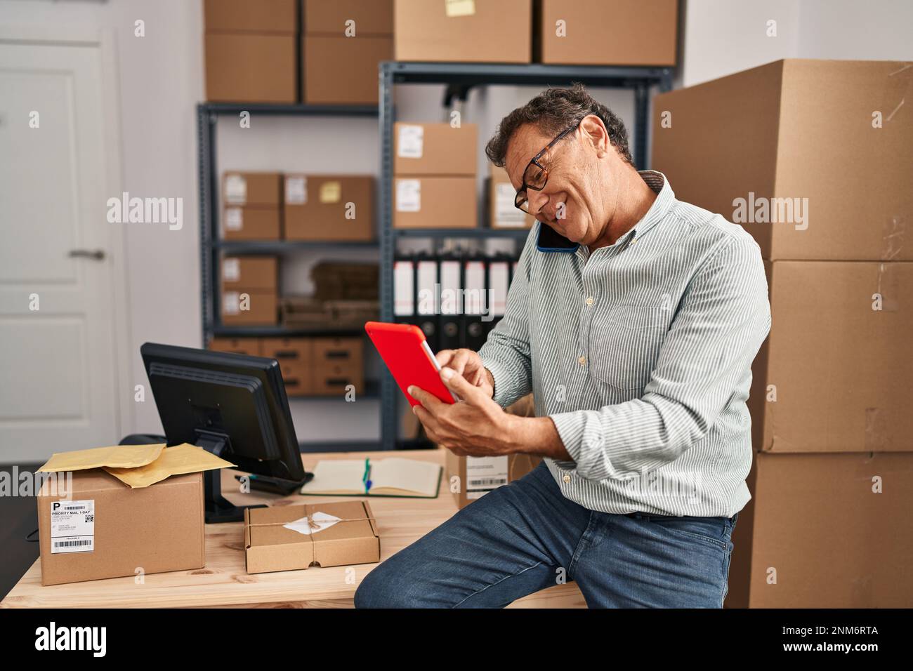 Middle age man ecommerce business worker talking on the smartphone and ...