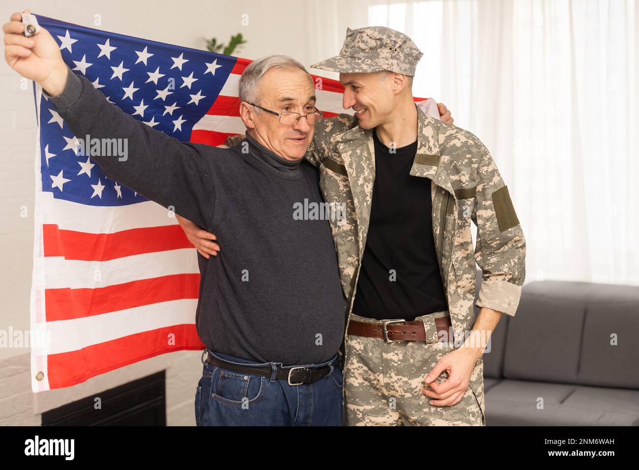 an elderly father and a military son saluting American flag Stock Photo - Alamy