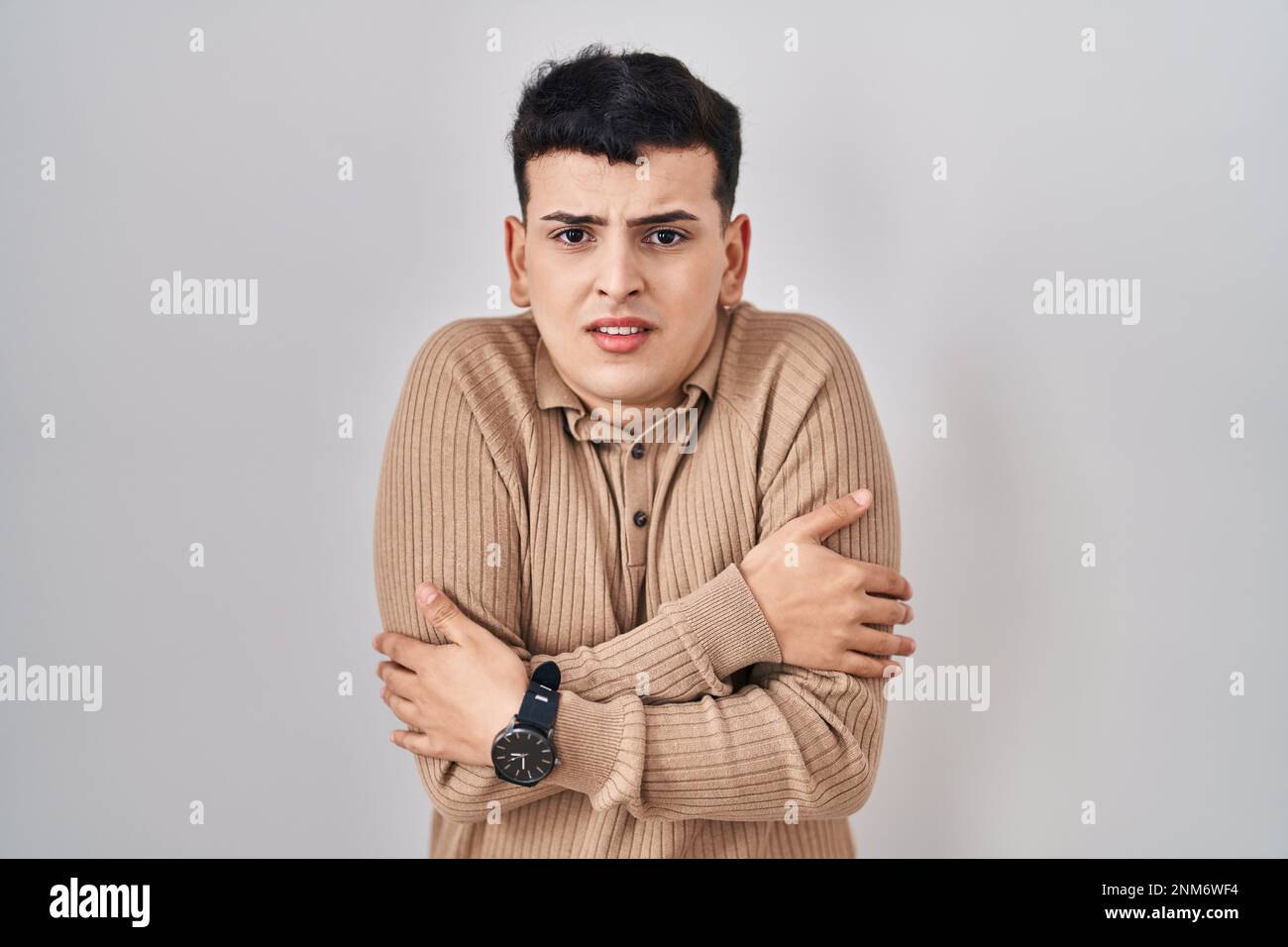 Non binary person standing over isolated background shaking and ...