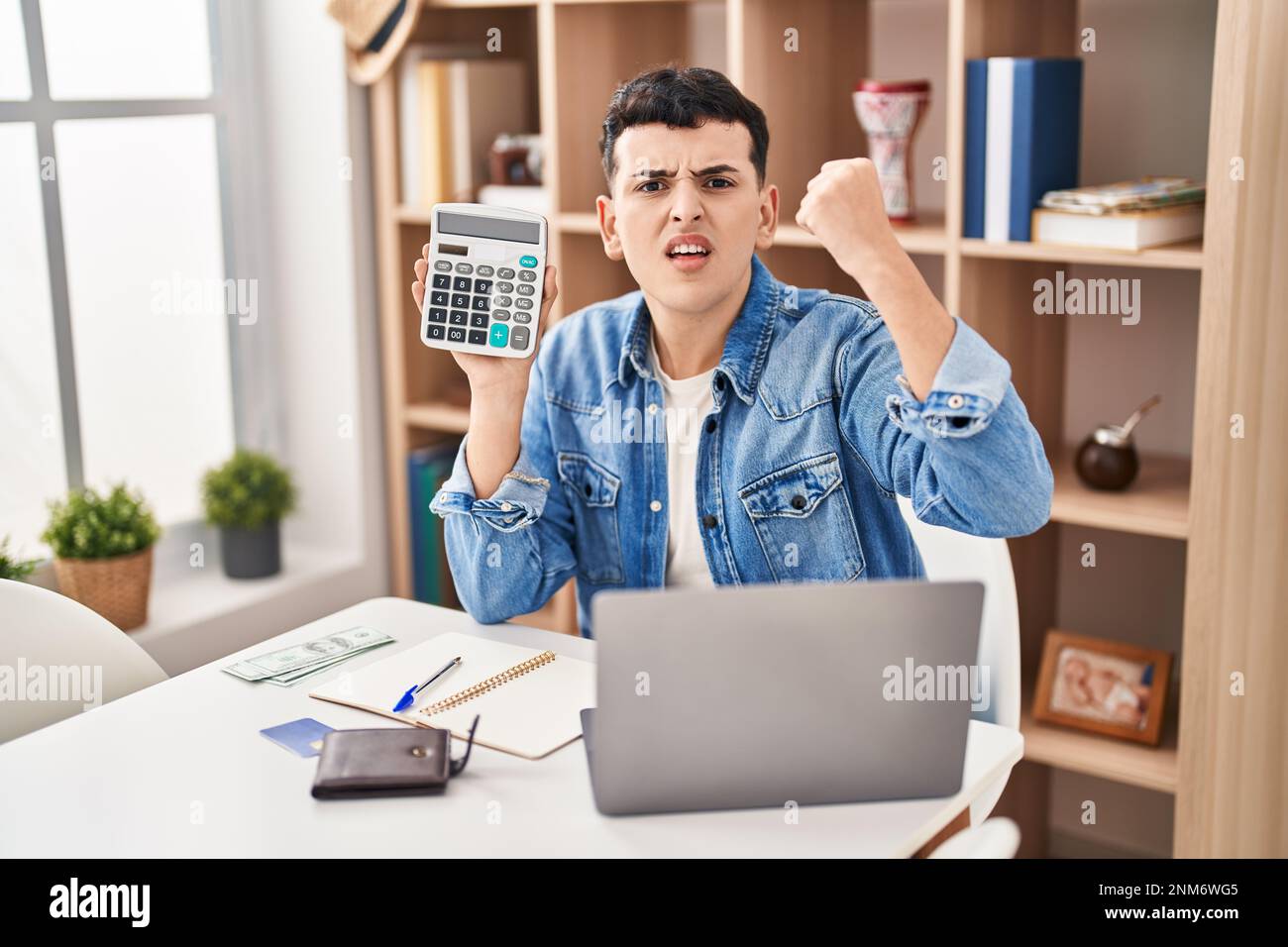Non binary person calculating money savings annoyed and frustrated ...