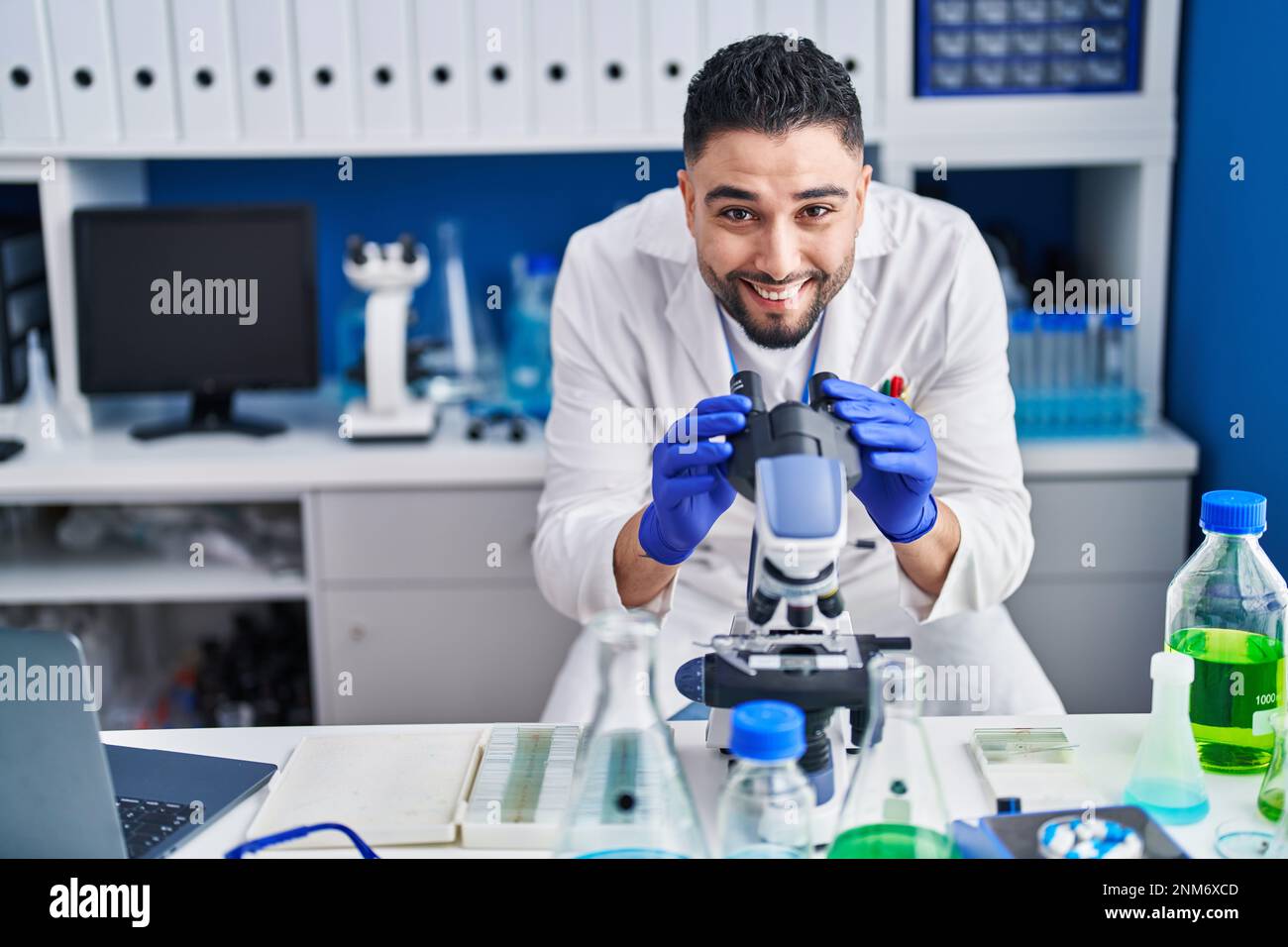 Young arab man scientist using microscope working at laboratory Stock ...