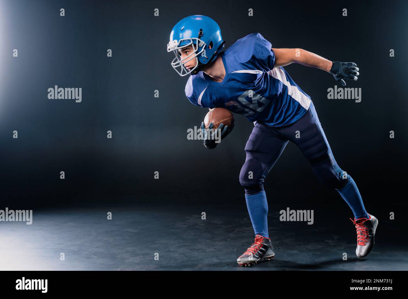 Full length portrait of a man in a blue american football uniform ...