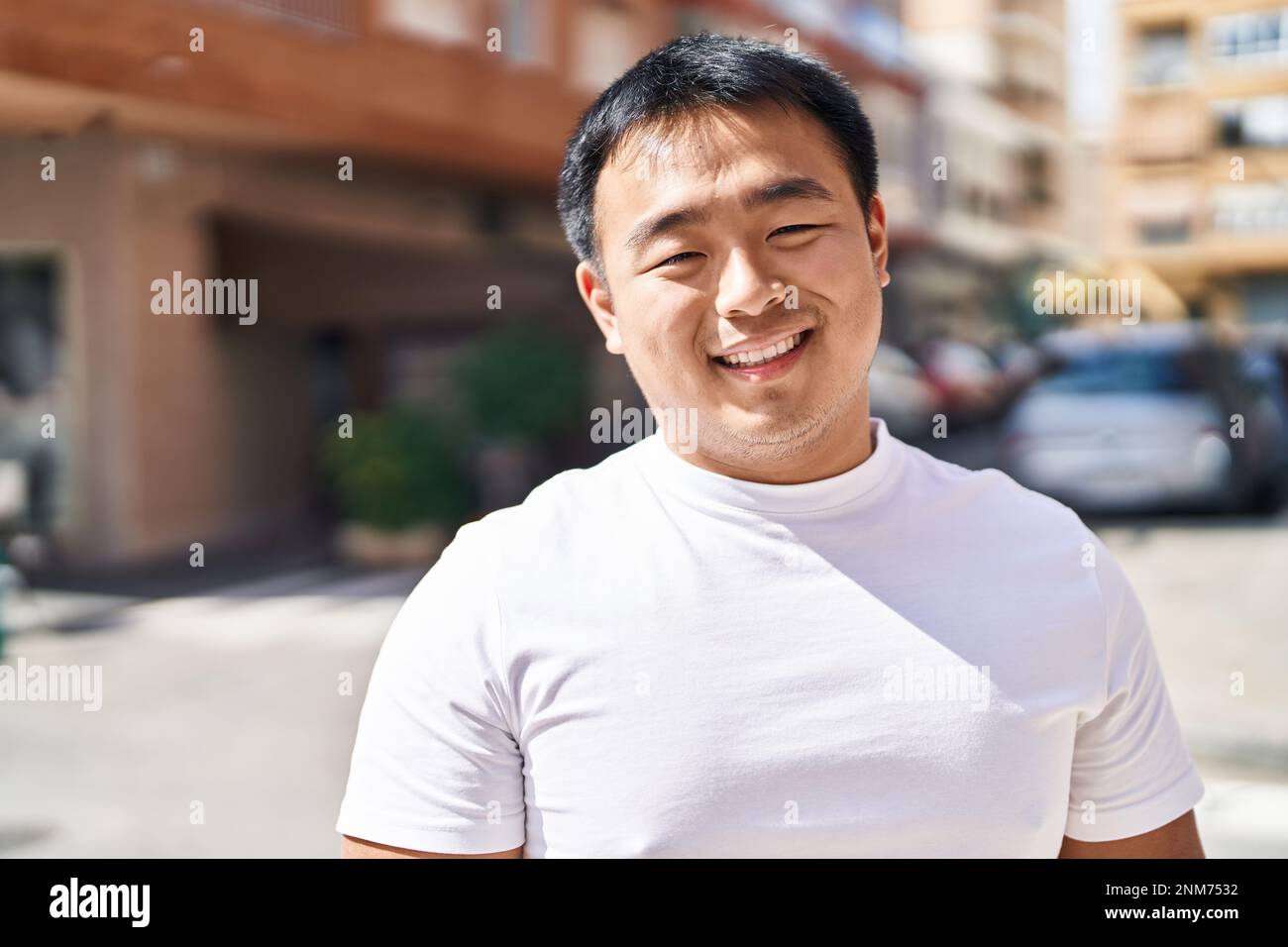 Young chinese man smiling confident standing at street Stock Photo - Alamy