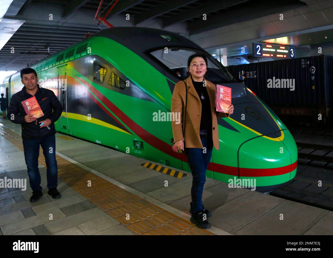 Passengers pose for photos with the first regular train serving on the ...