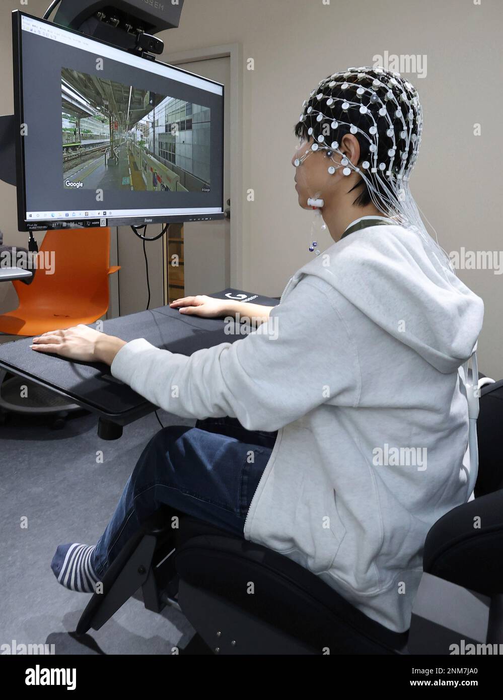 A photo shows the research on brain waves (electroencephalogram) by Keio University Professor ...