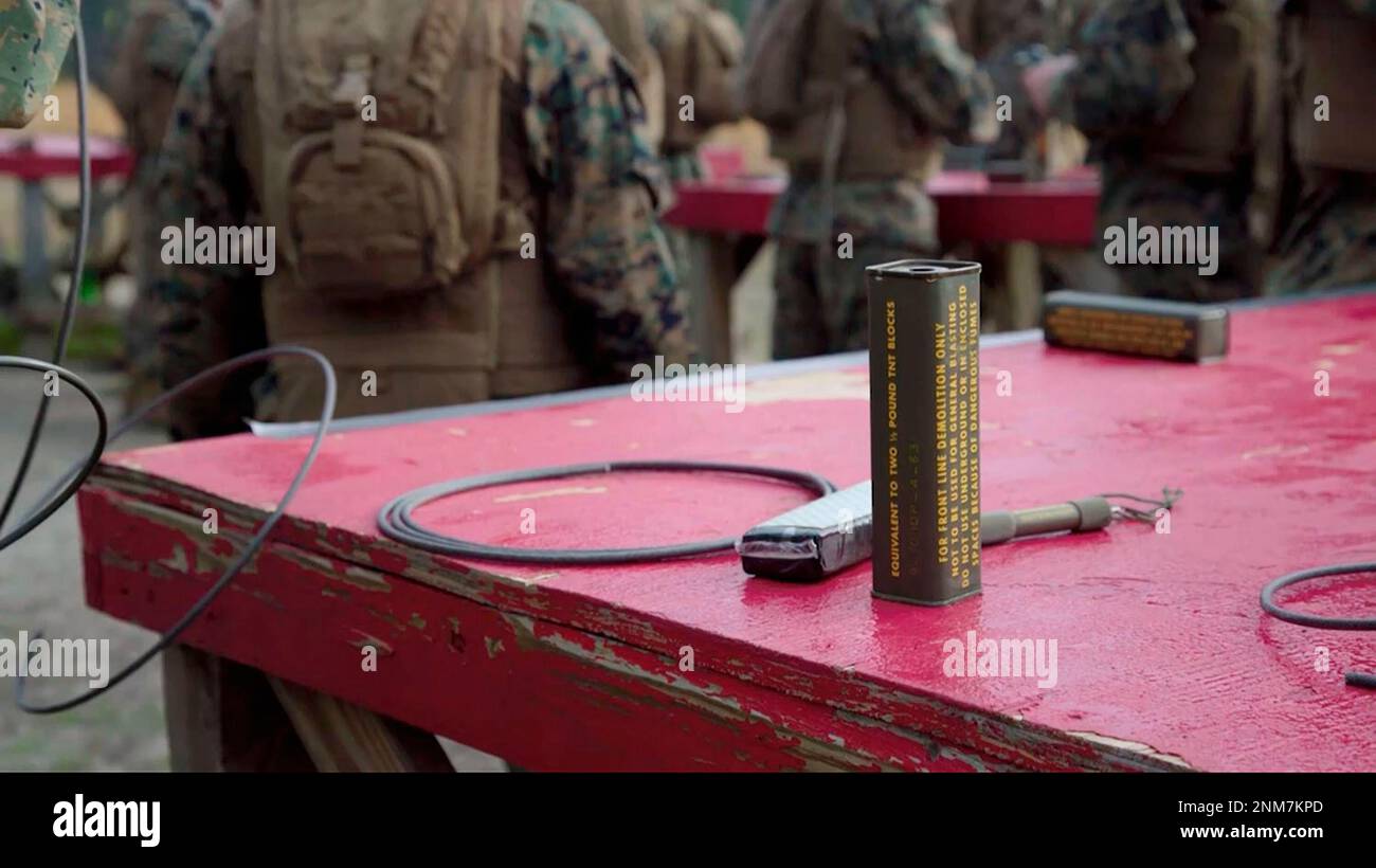 A photo showing a block of TNT as Marines train in the background at ...