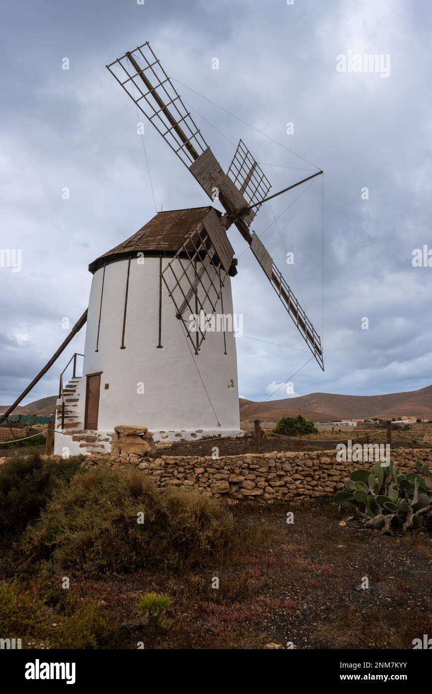White facade of the windmill base. Located in the nature, between ...