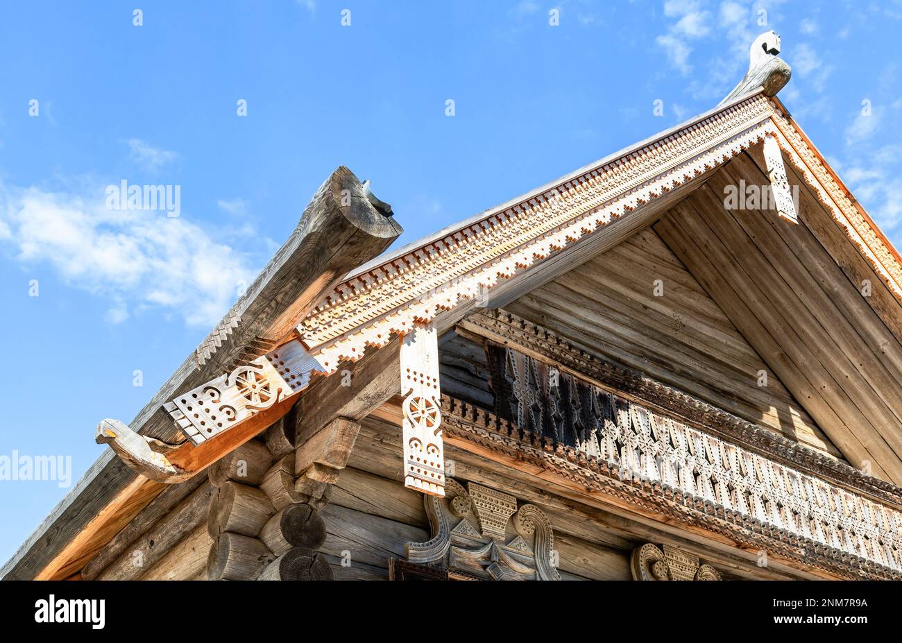 Traditional wooden handmade carved decorations on the roof of a wooden ...