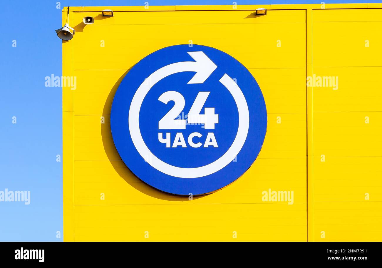 24 hours blue sign open or working around the clock hanging on yellow ...