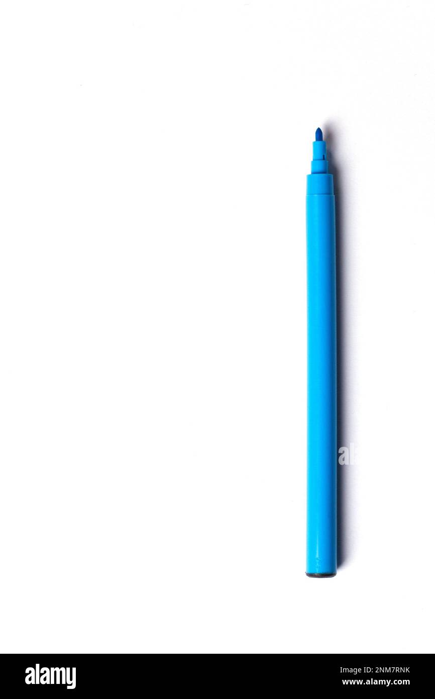 A blue felt-tip pen with a cap lies on a white background. empty space ...