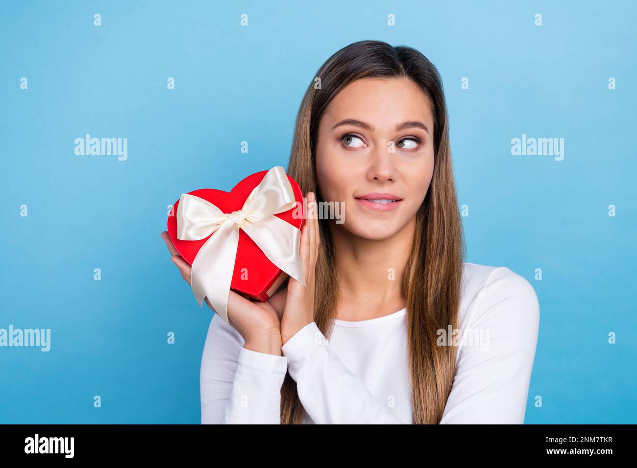 Photo of charming tricky woman wear white shirt biting lip holding ...