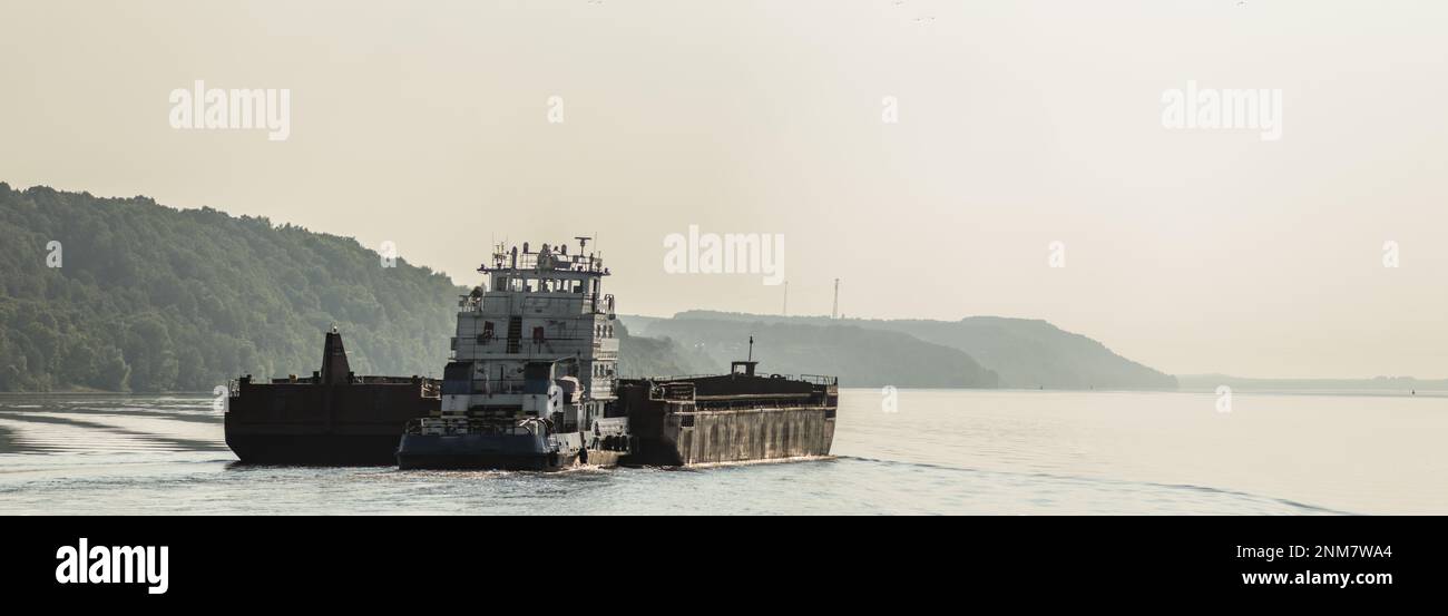 A large cargo barge transports cargo by river to the main port for ...