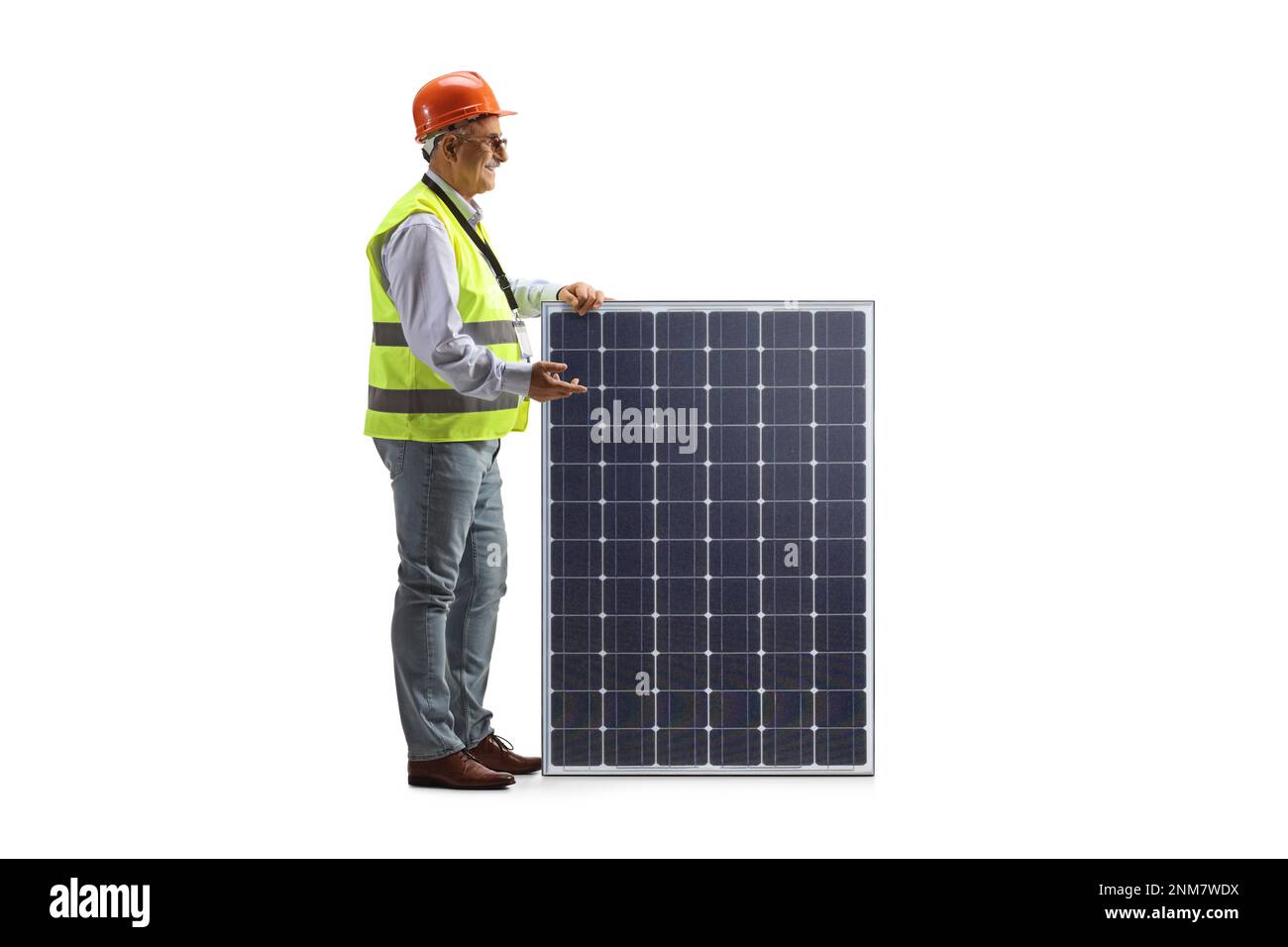 Mature male engineer with a vest and hardhat standing next to a ...