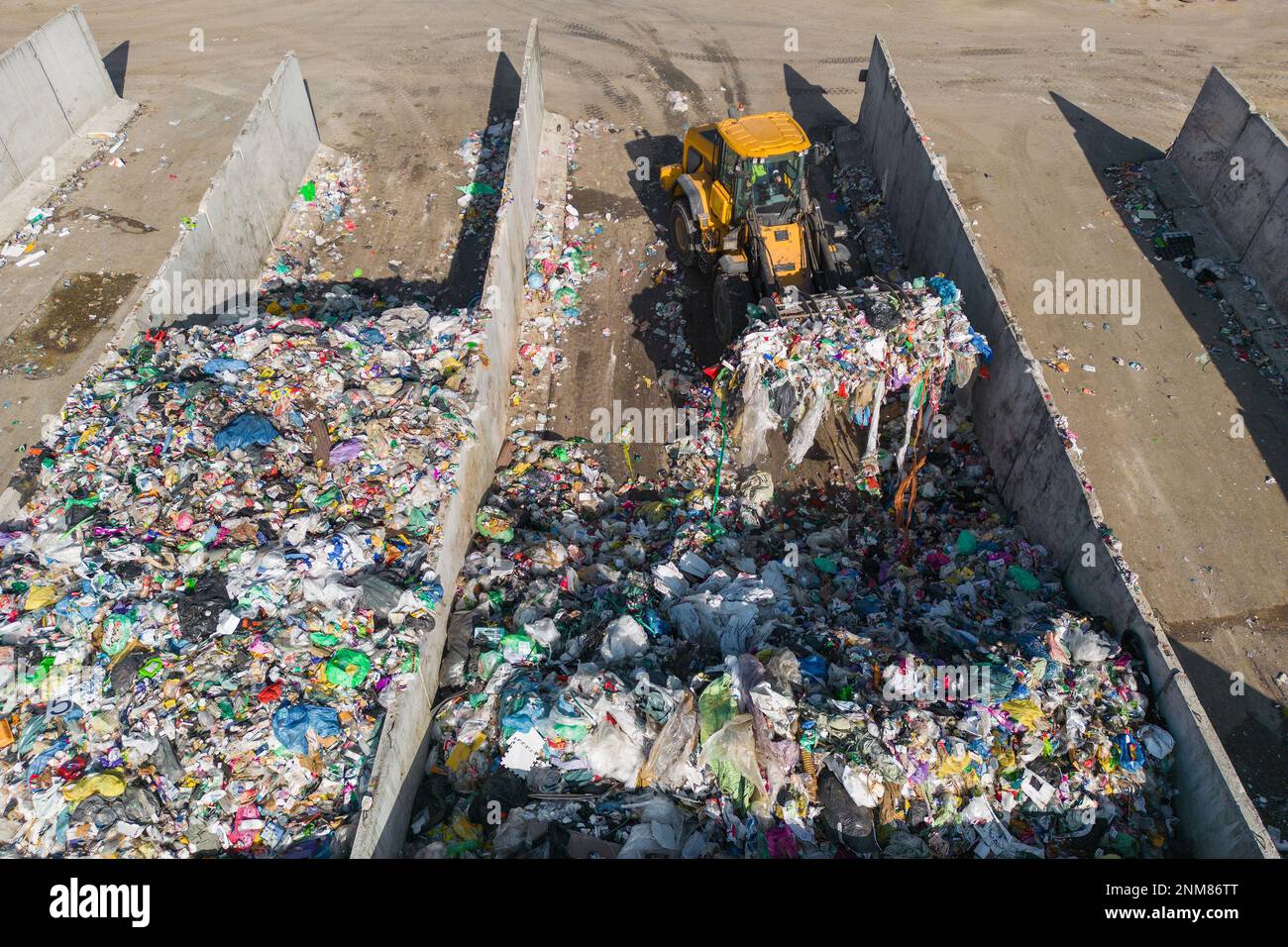 Skid steer loader moving plastic garbage with scrap grapple on the ...