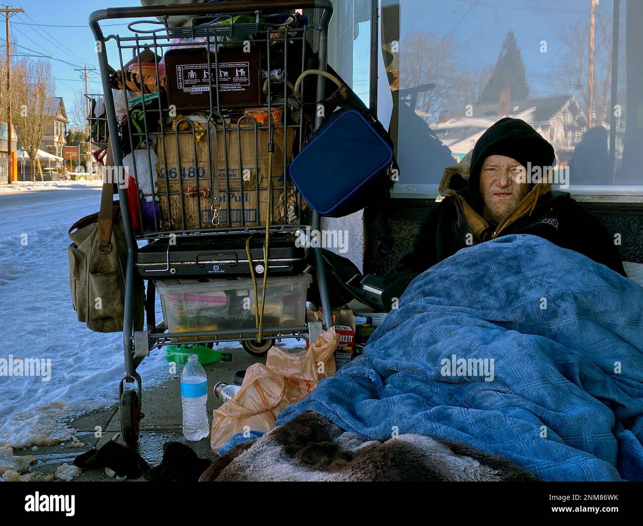 Tim Varner, 57, uses blankets to stay warm in the snow as he huddles ...