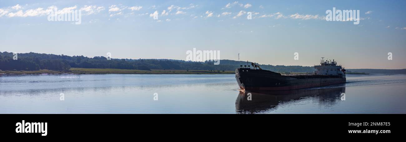 A large cargo barge transports cargo by river to the main port for ...