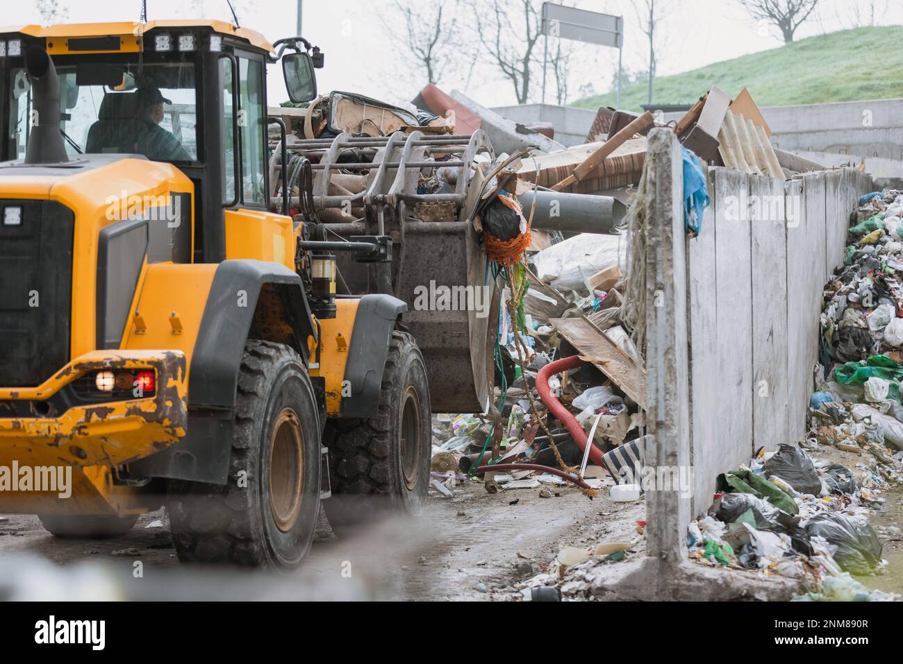 Front loader with scrap handling grapple bucket moving forward and ...