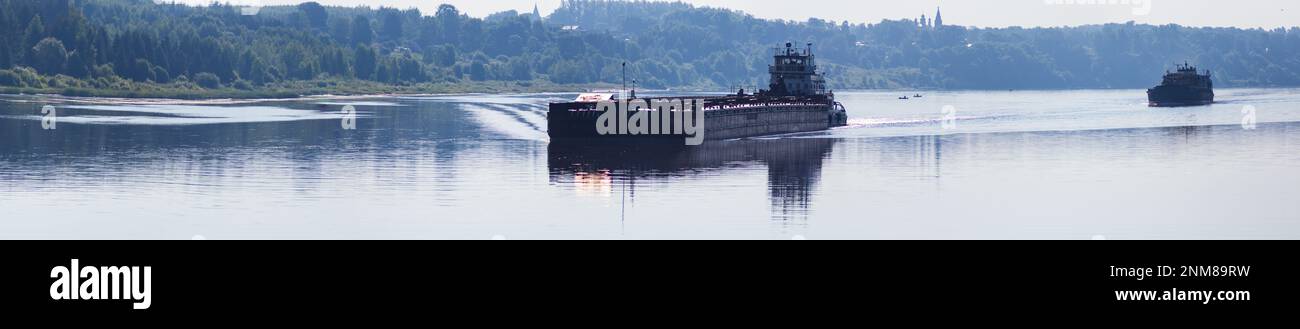 A large cargo barge transports cargo by river to the main port for ...