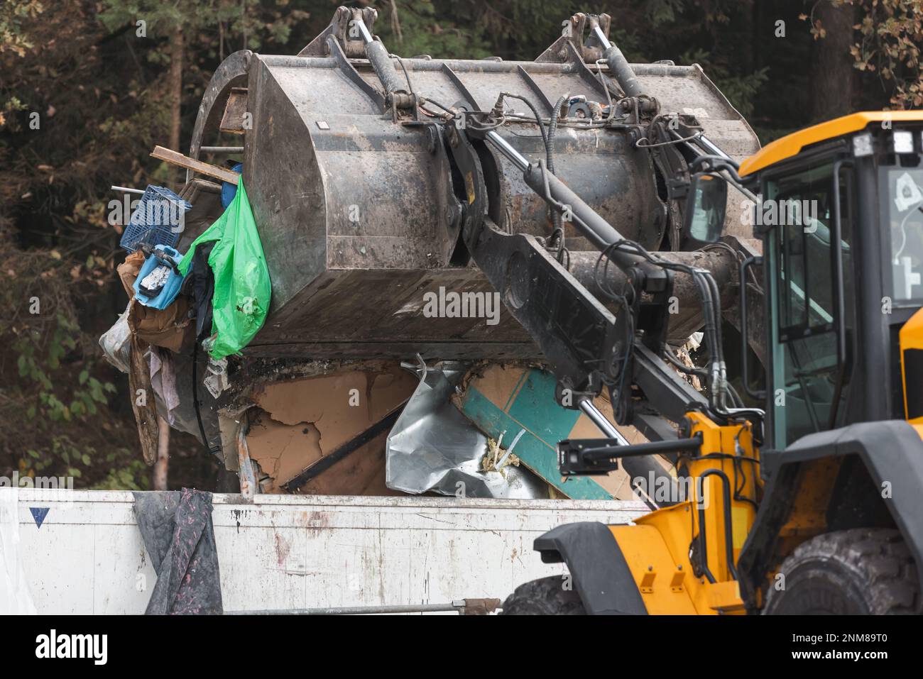 Skid steer loader moving garbage at the landfill site, before ...