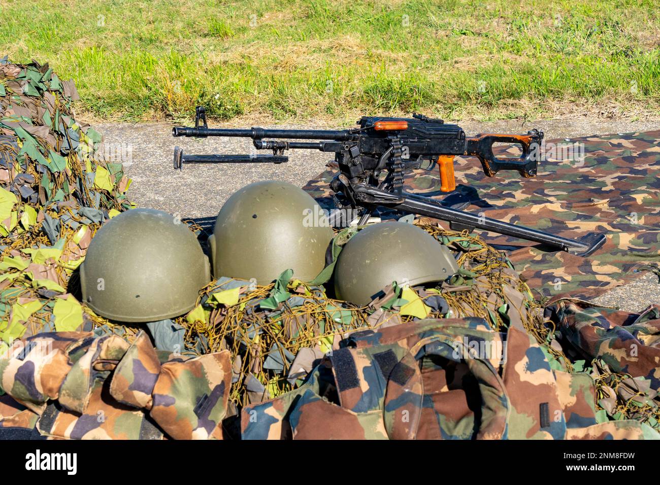 Soviet-made PK machine gun with three military helmets and camouflage ...