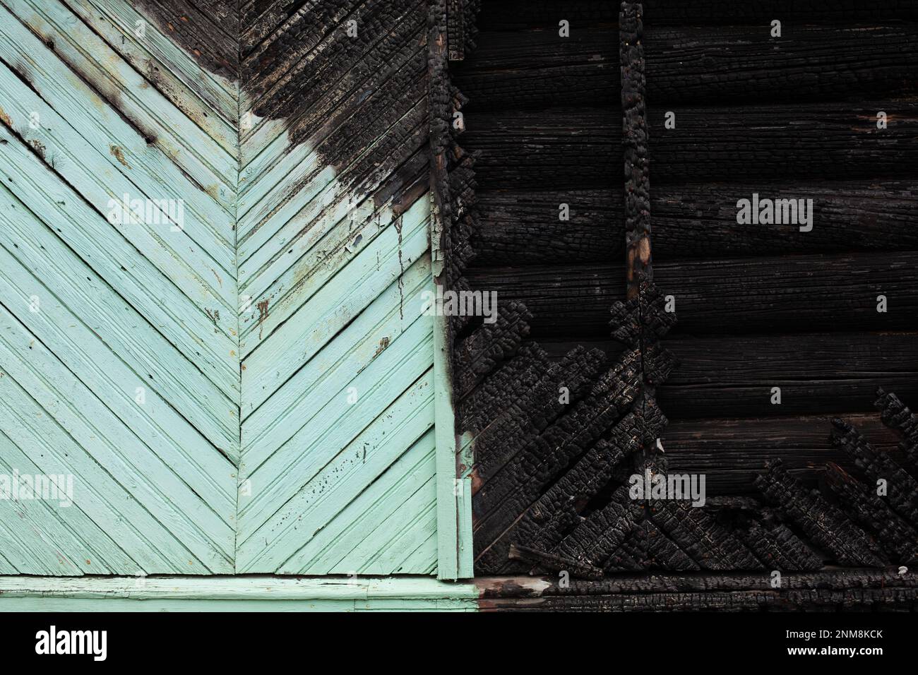 Black half burned blue wooden house Stock Photo - Alamy