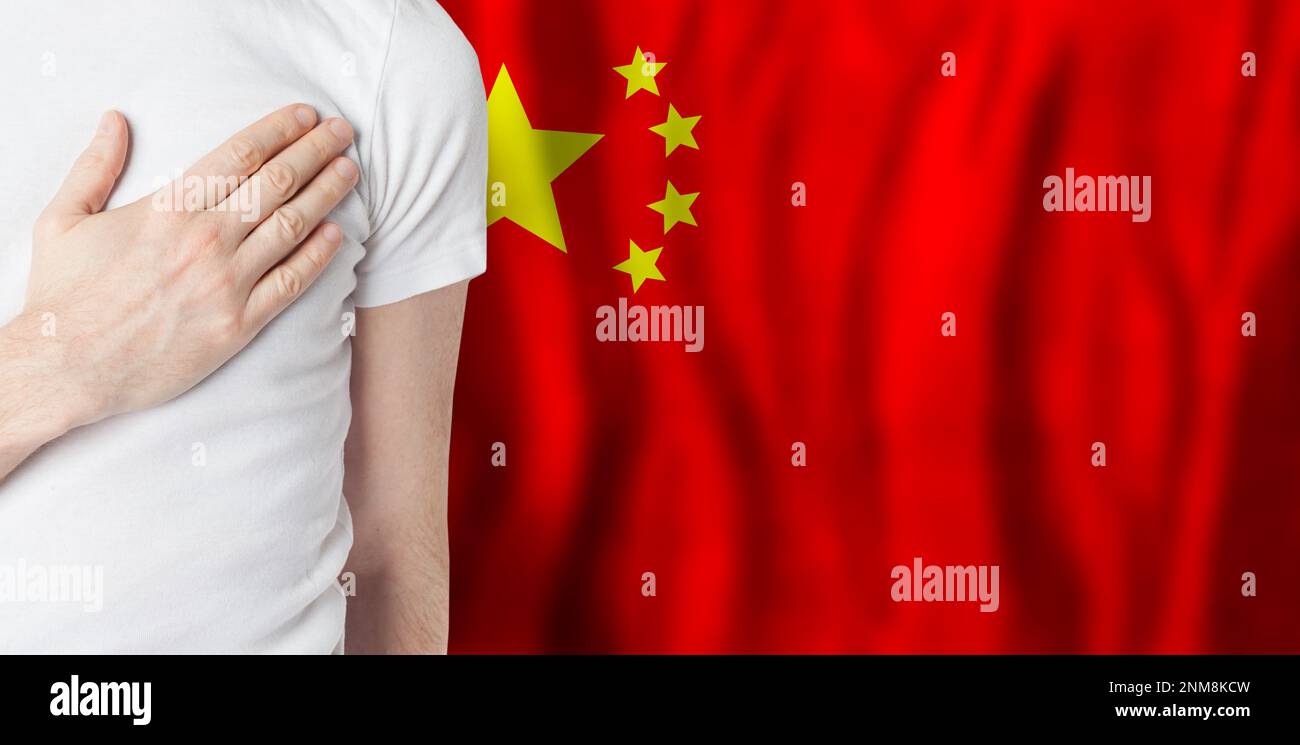 Chinese person with hand on heart on the background of China flag ...