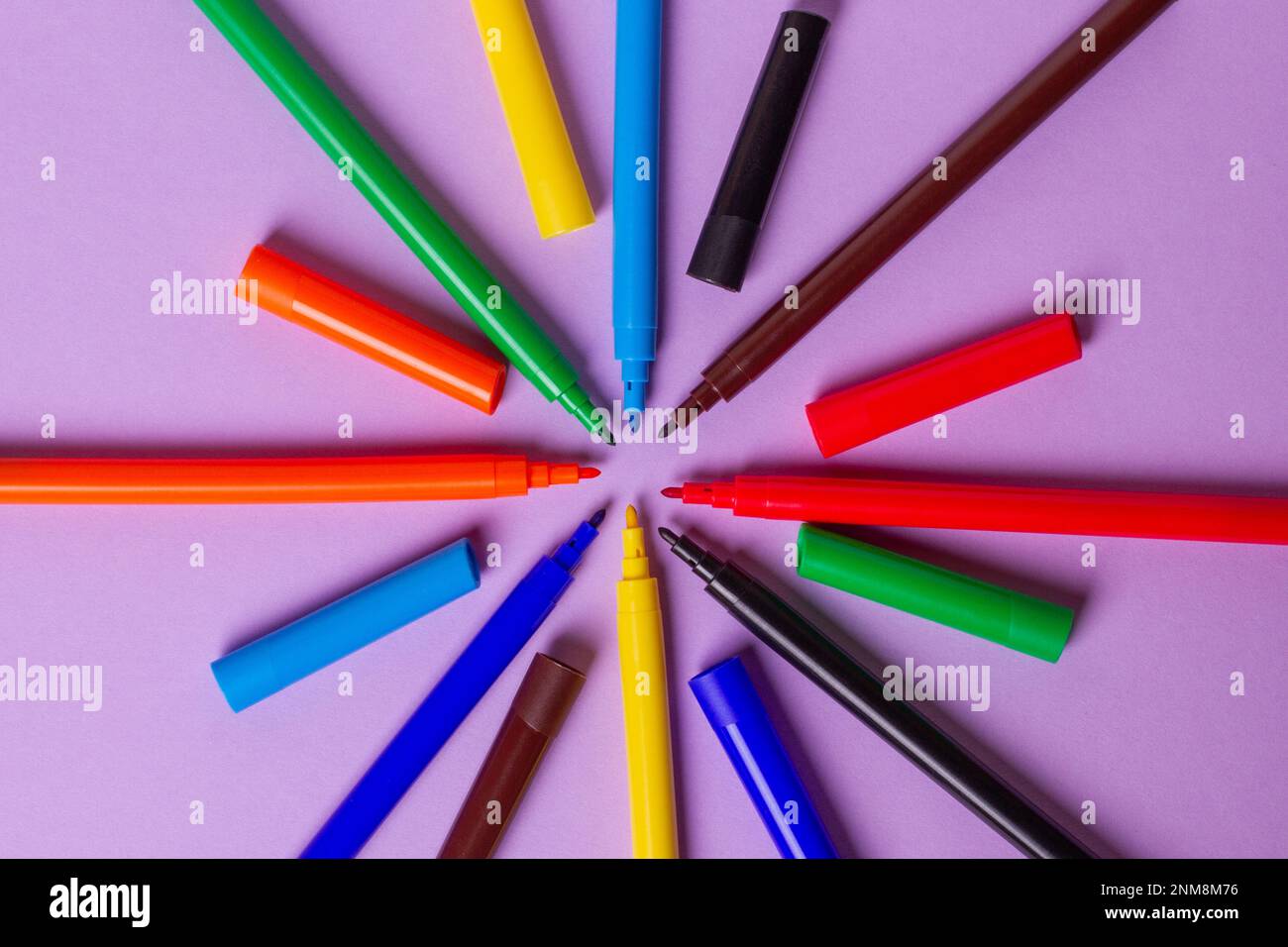 Felt-tip pens without caps of different colors on a purple background ...