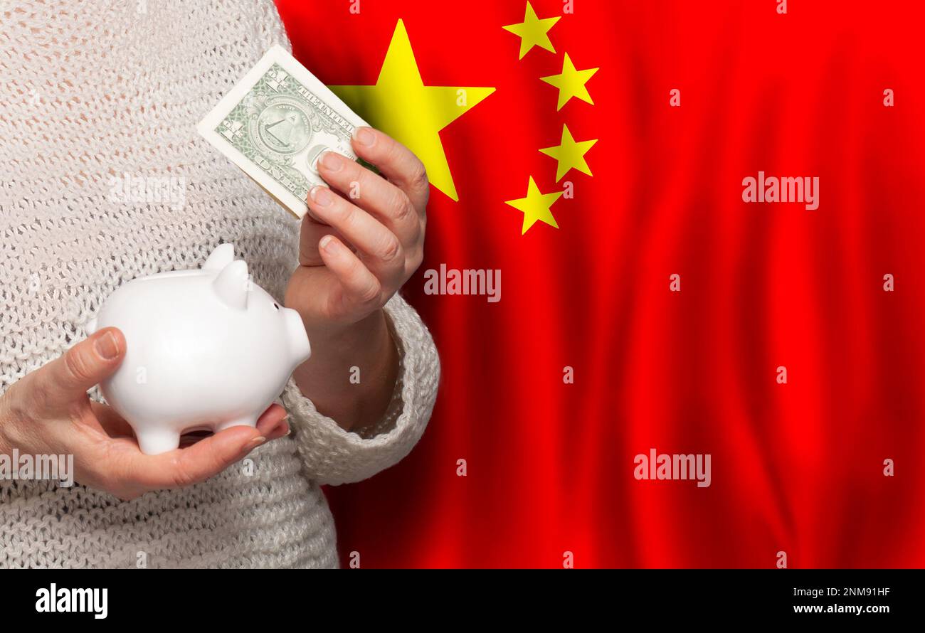 Chinese woman with money bank on the background of China flag ...