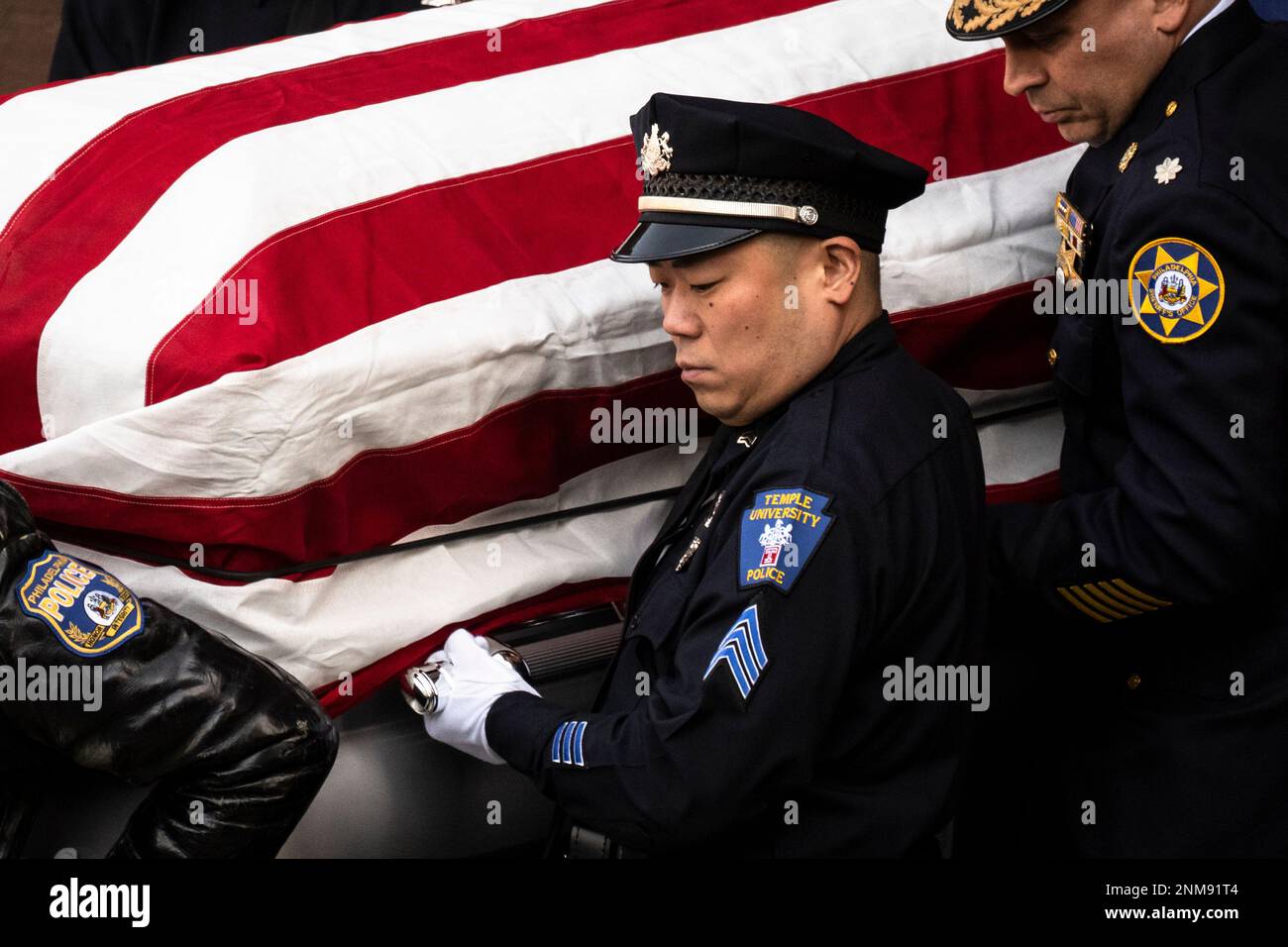 A honor guard carries the casket containing the remains of Temple ...