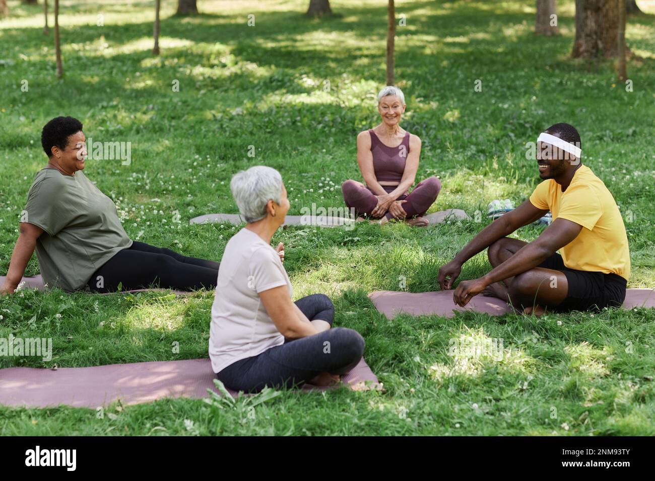 Side view portrait of male yoga instructor coaching outdoor meditation ...