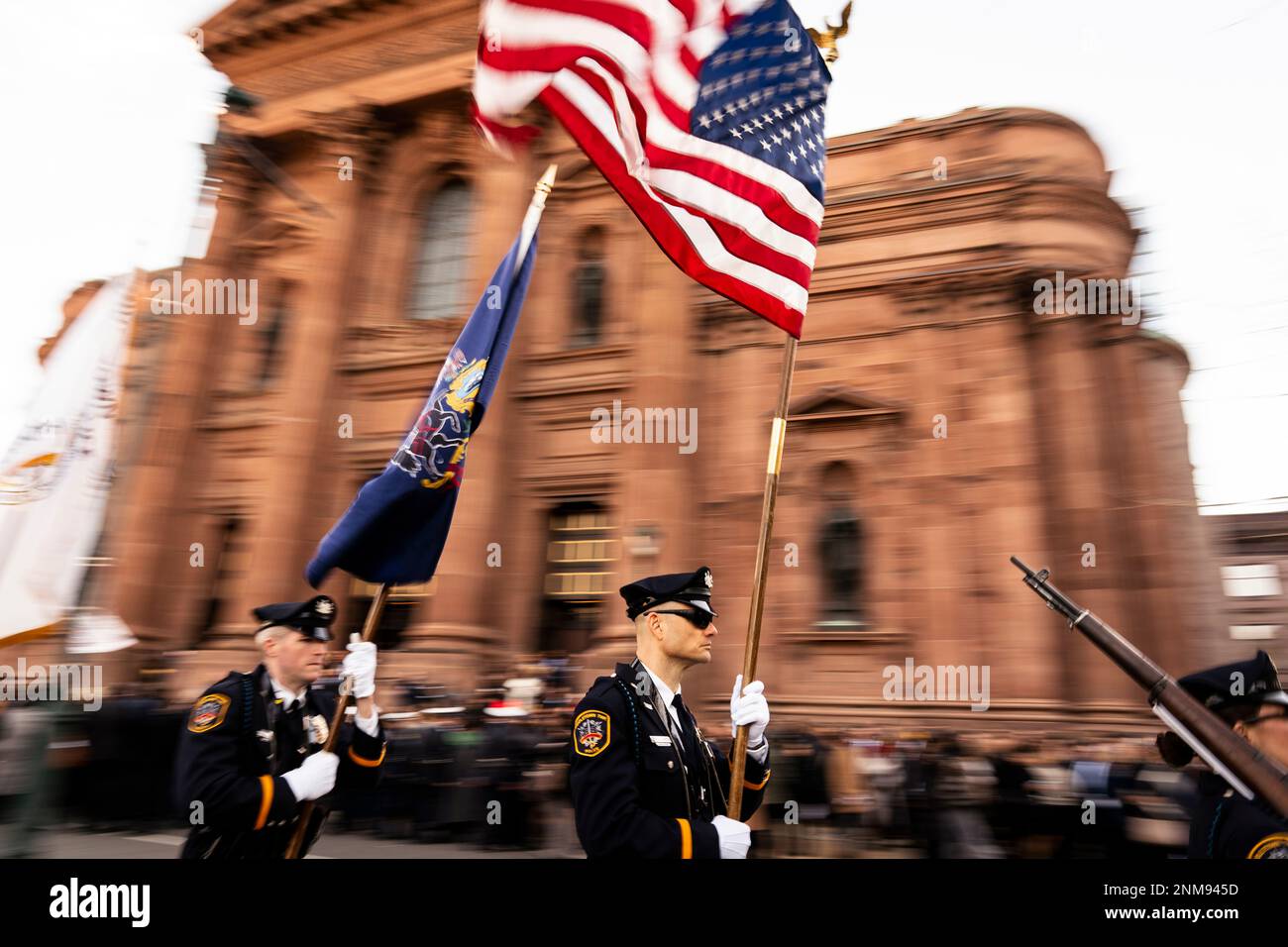 A color guard marches away after the casket containing the remains of ...