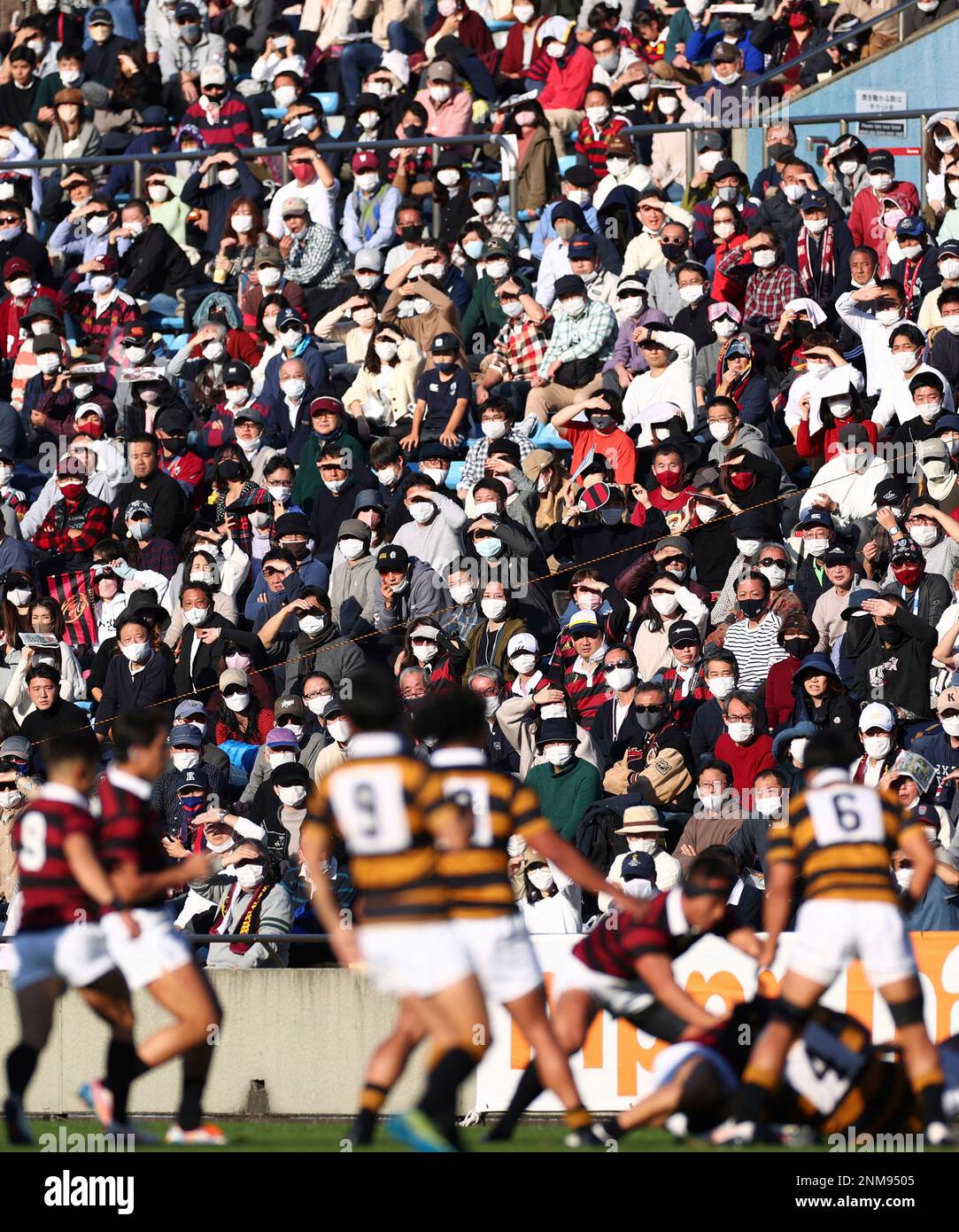 Spectators wearing masks enjoy watching a rugby match between Waseda ...