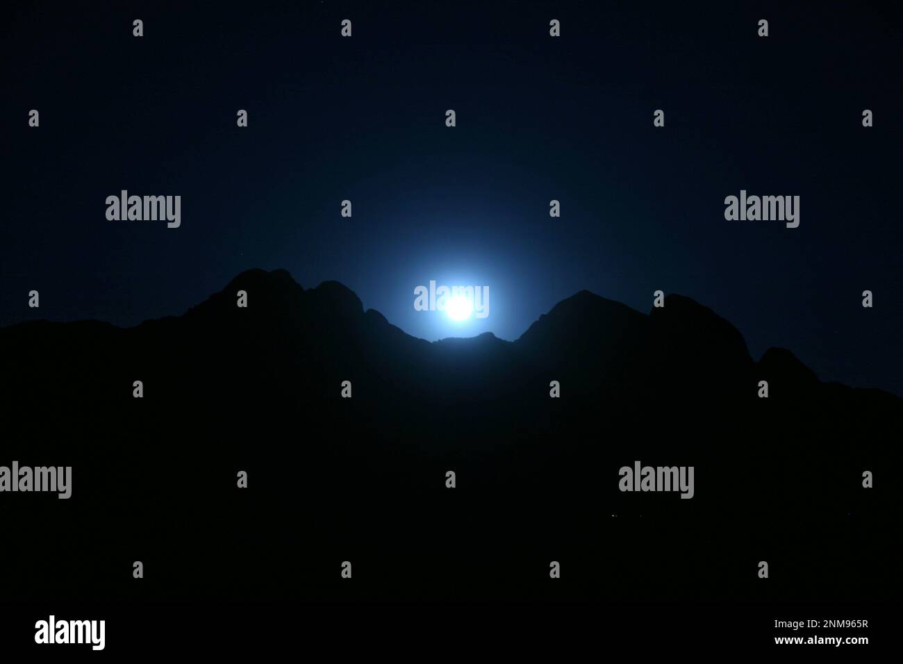 super full moon rise between mountain peaks Stock Photo - Alamy