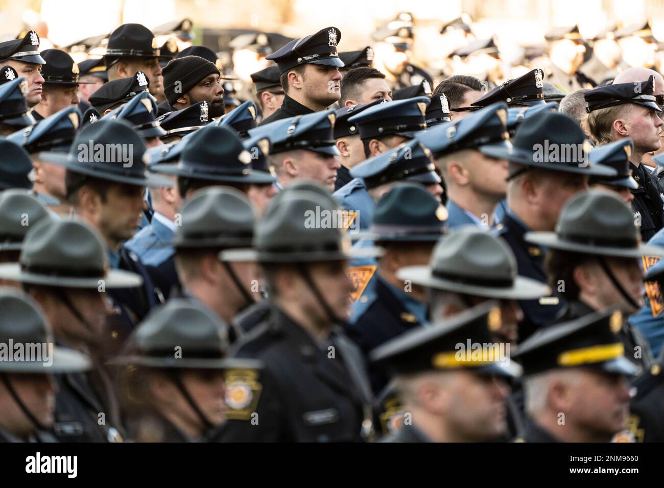 Law enforcement officers gather as a honor guard carries the casket ...