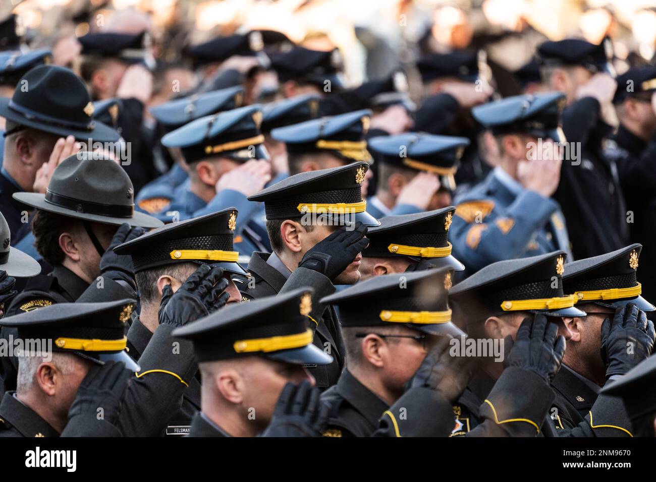 Law enforcement officers gather as a honor guard carries the casket ...
