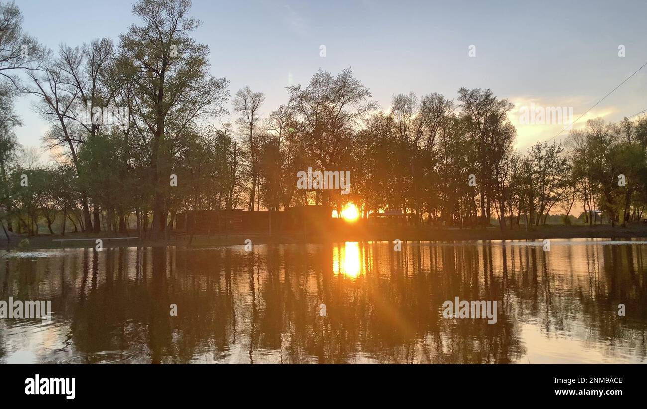 A beautiful sunset over the river with calm water. The sun shines ...